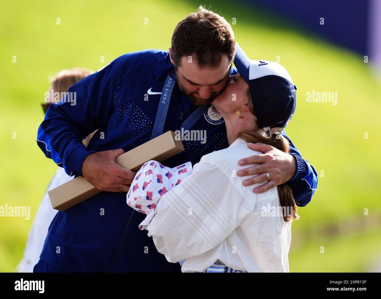 Meredith Scudder, wife of Scottie Scheffler (left), cradles their son ...