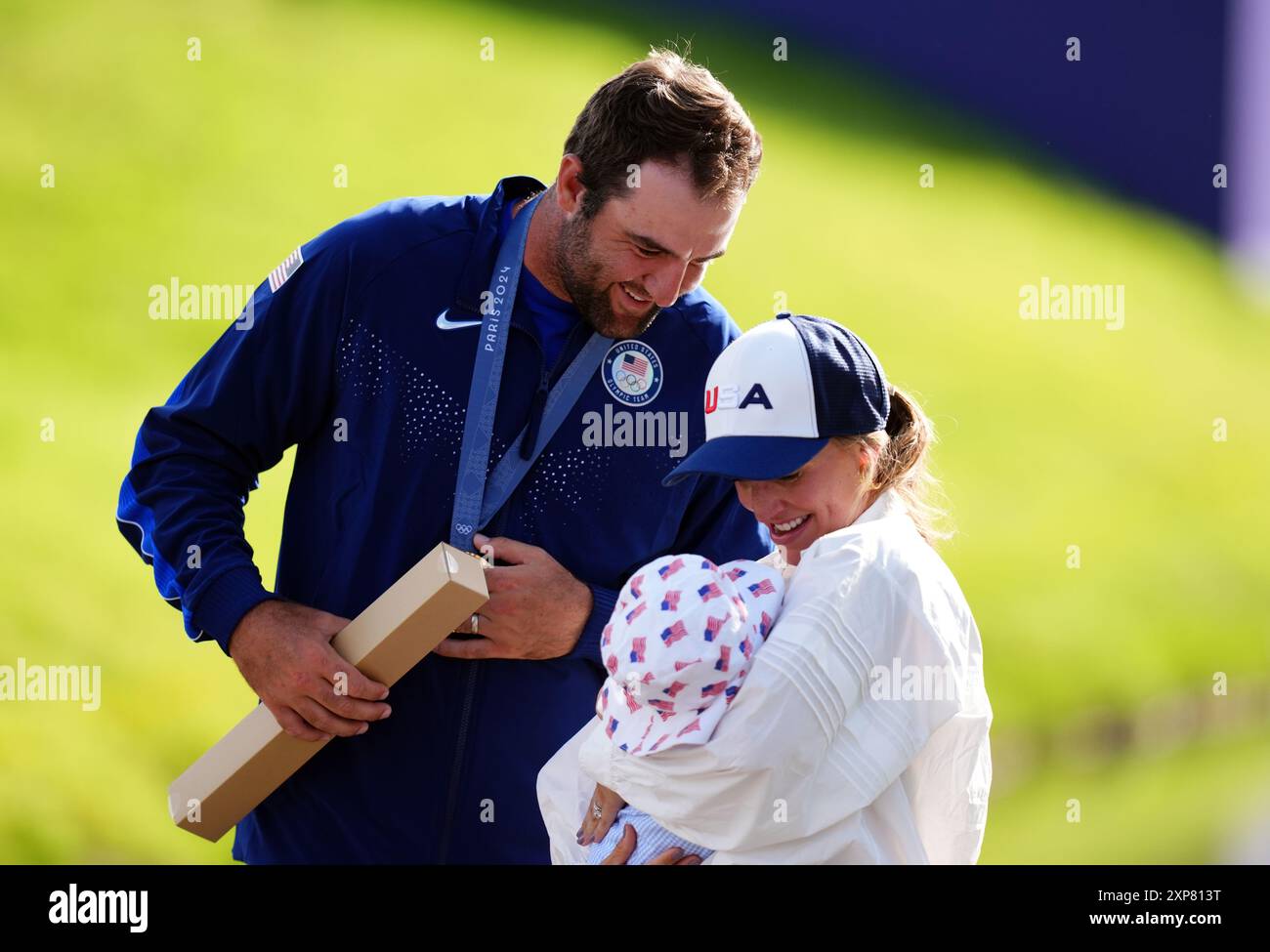 Meredith Scudder, wife of Scottie Scheffler (left), cradles their son ...