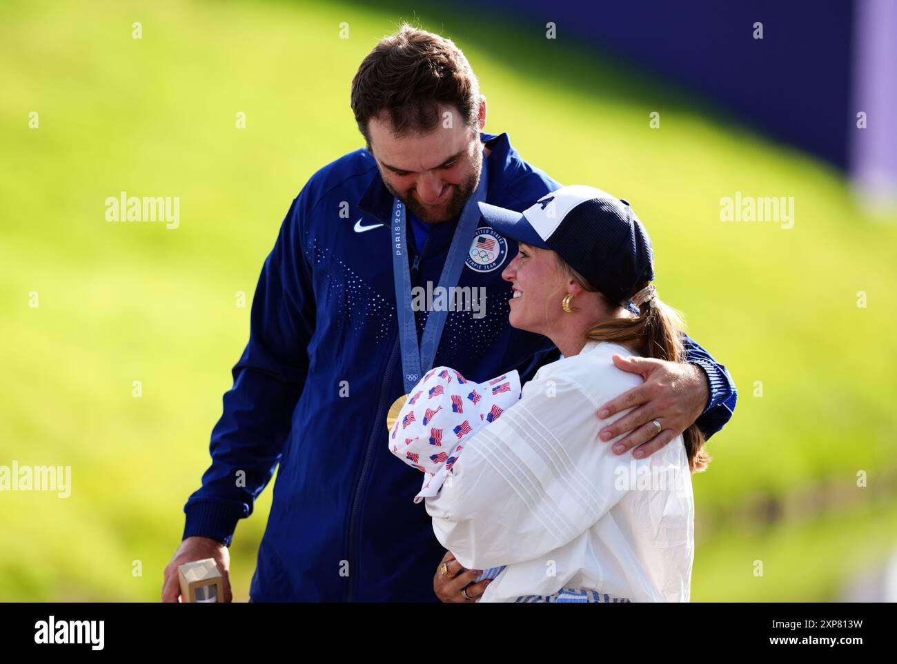 Meredith Scudder, wife of Scottie Scheffler (left), cradles their son ...
