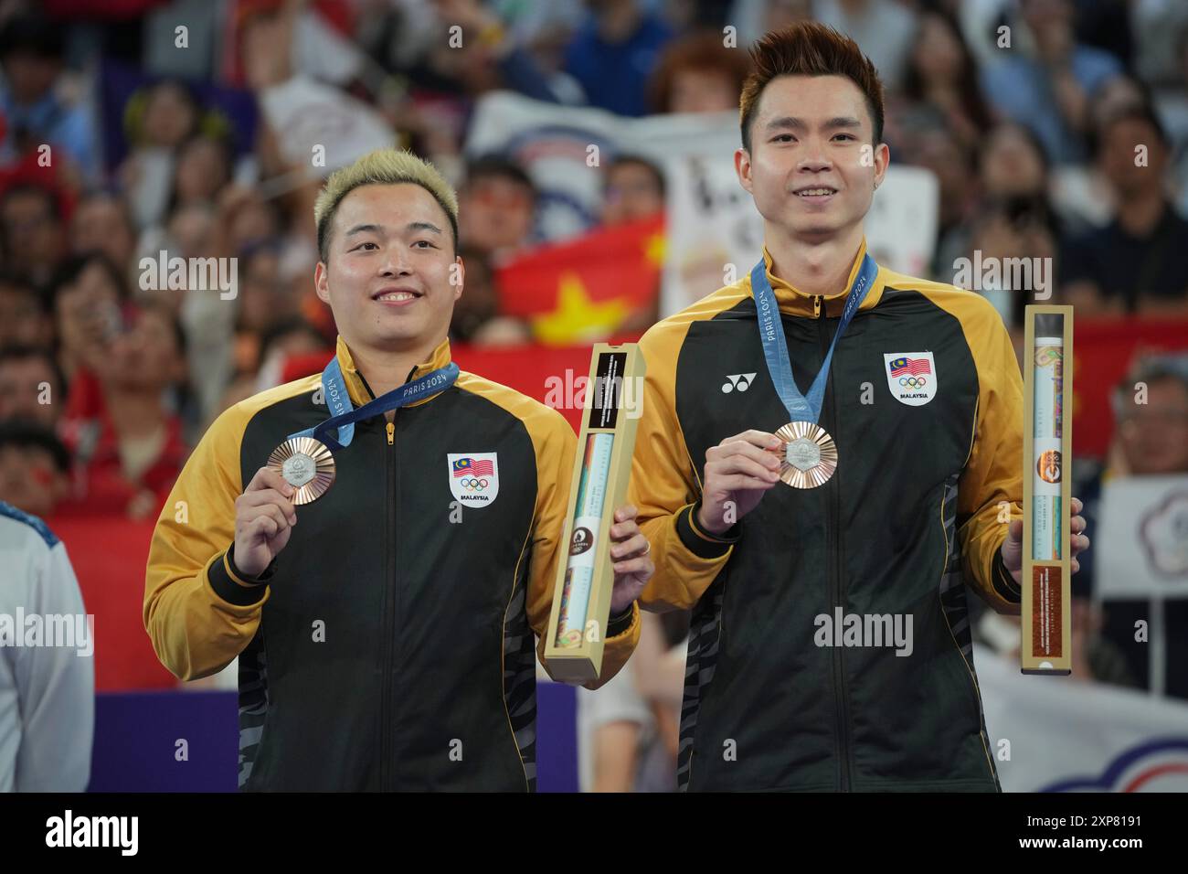 Bronze medalists, Malaysia's Aaron Chia, left, and Soh Wooi Yik celebrate on the podium during ...