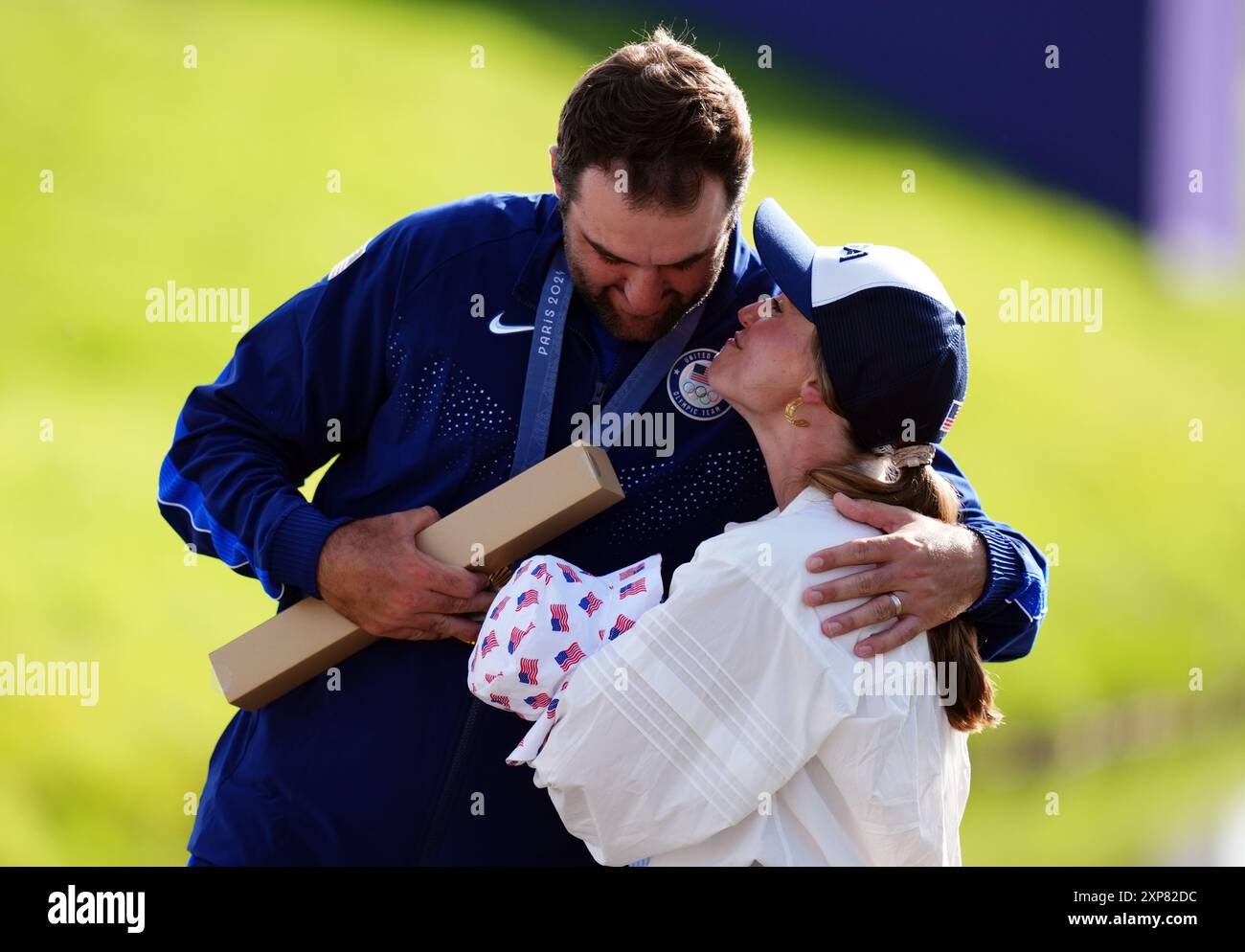 Meredith Scudder, wife of Scottie Scheffler (left), cradles their son ...