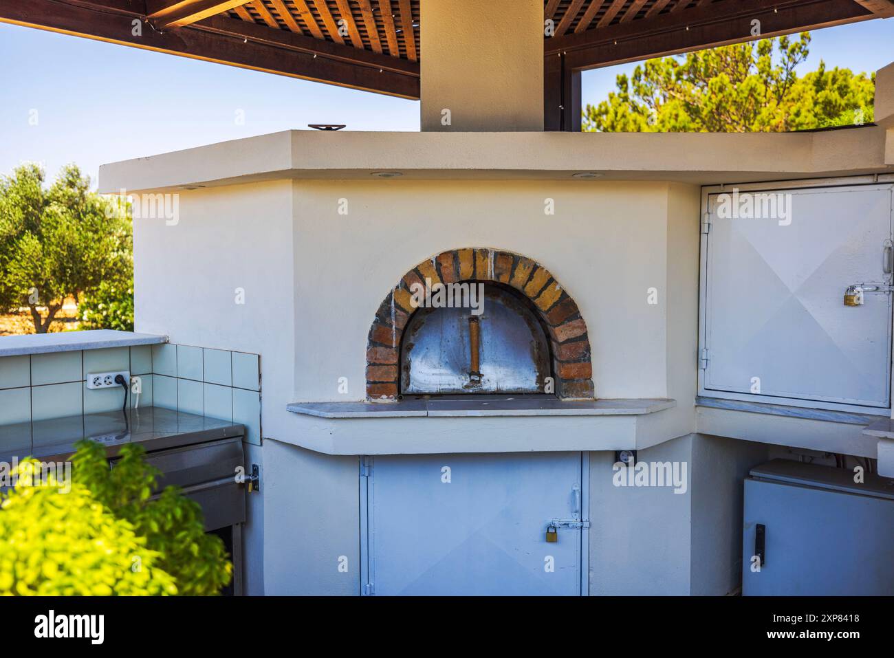Outdoor brick oven in hotel's modern kitchen area with tiled ...