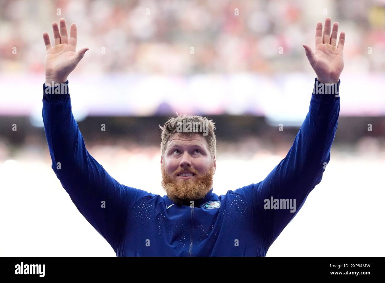 Men's shot put gold medalist Ryan Crouser, of the United States waves ...