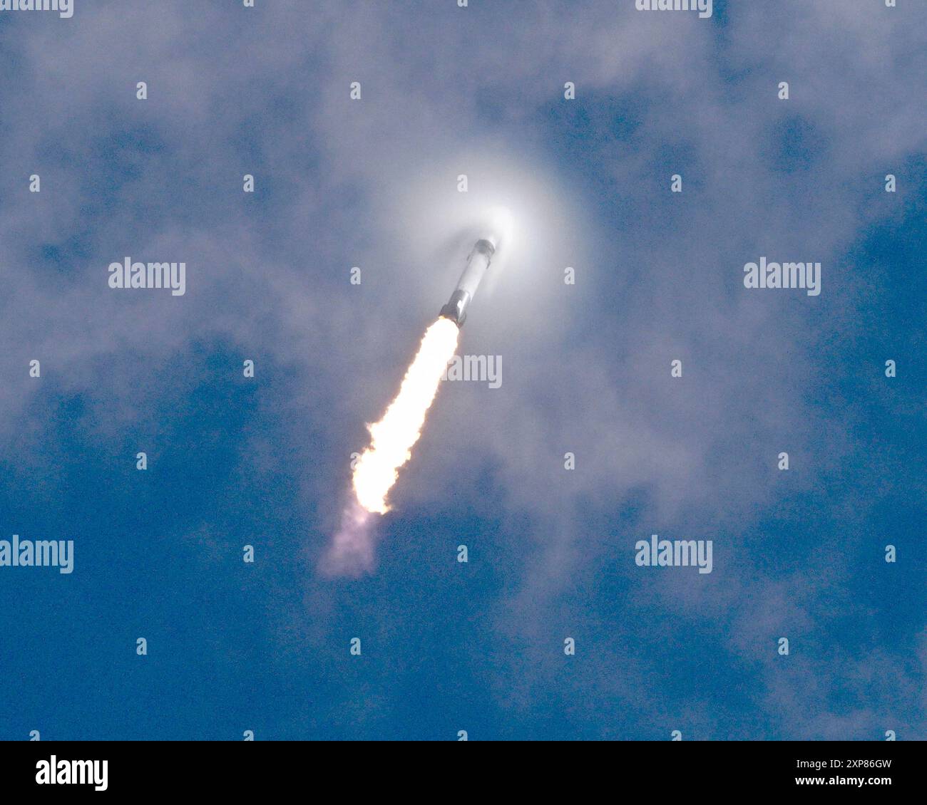 A SpaceX Falcon 9 rocket creates a vapor cone as it launches the ...