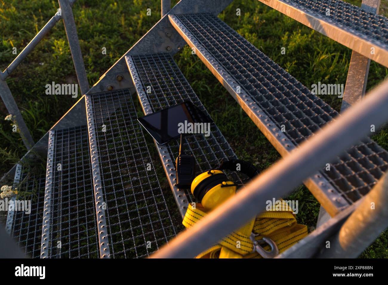 Digital tablet, headphones and climber's rope are on the ladder of the ...