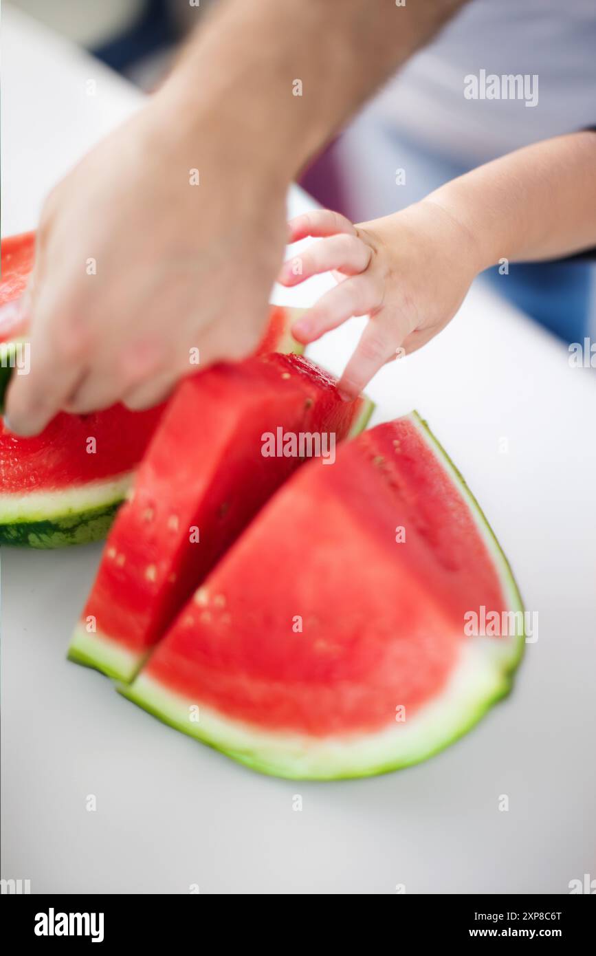 a child takes a piece of watermelon with his hand Stock Photo - Alamy