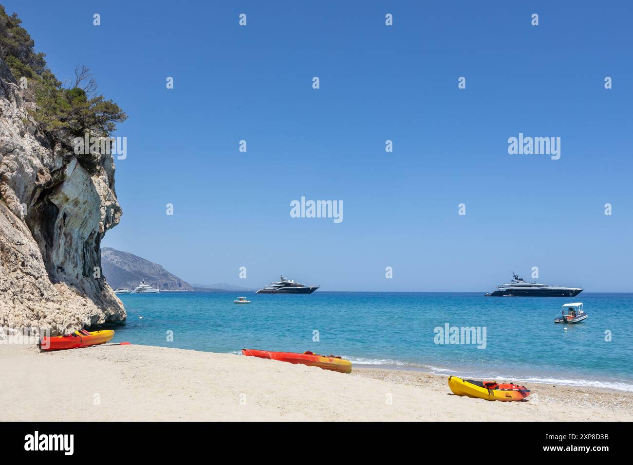 Luxury Yachts and Colorful Kayaks at Cala Luna Beach Stock Photo - Alamy