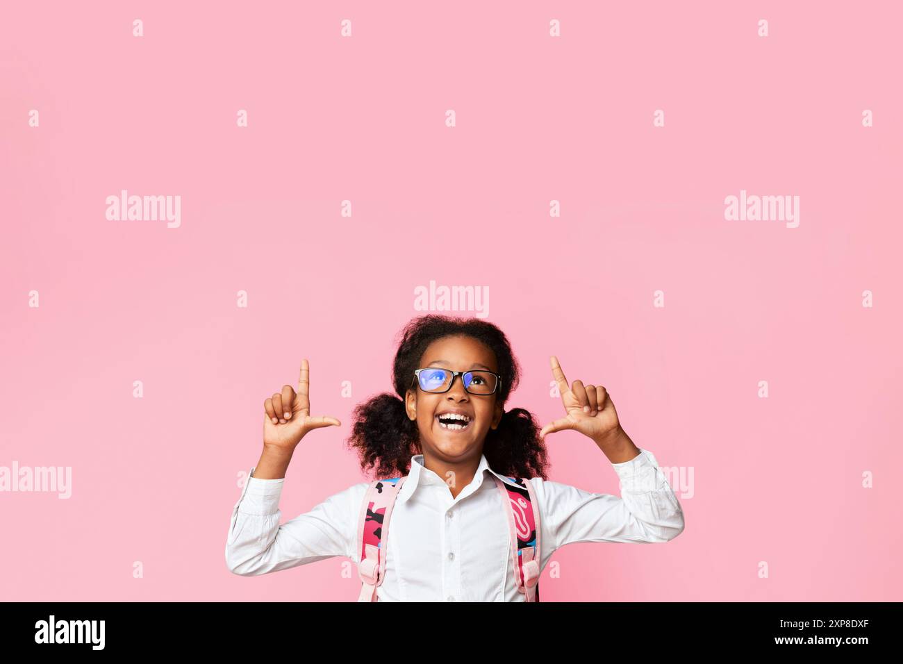 Elementary Student Girl Pointing Fingers At Empty Space, Studio Shot ...