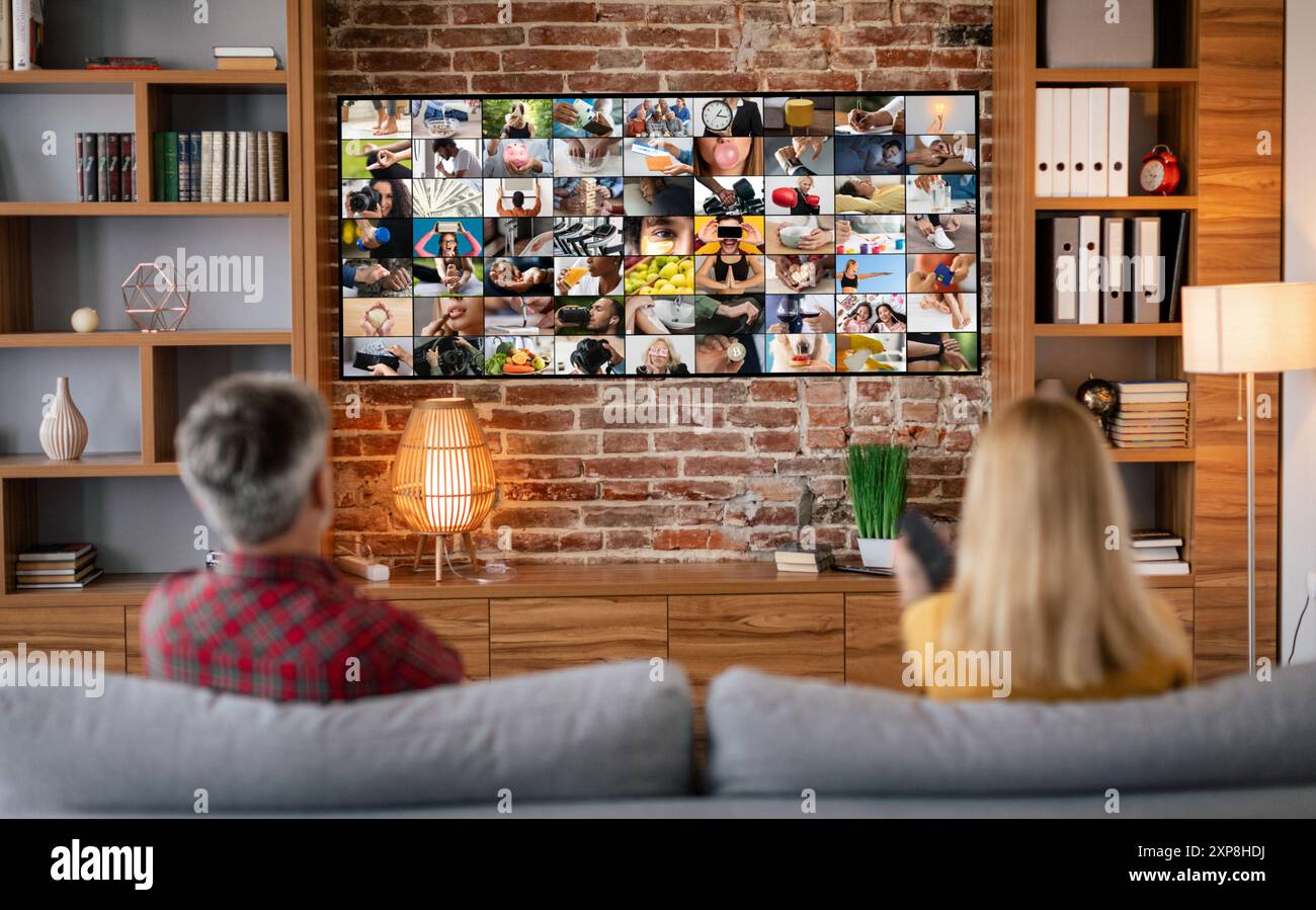 Couple Watching Television in Living Room With Brick Wall Stock Photo ...