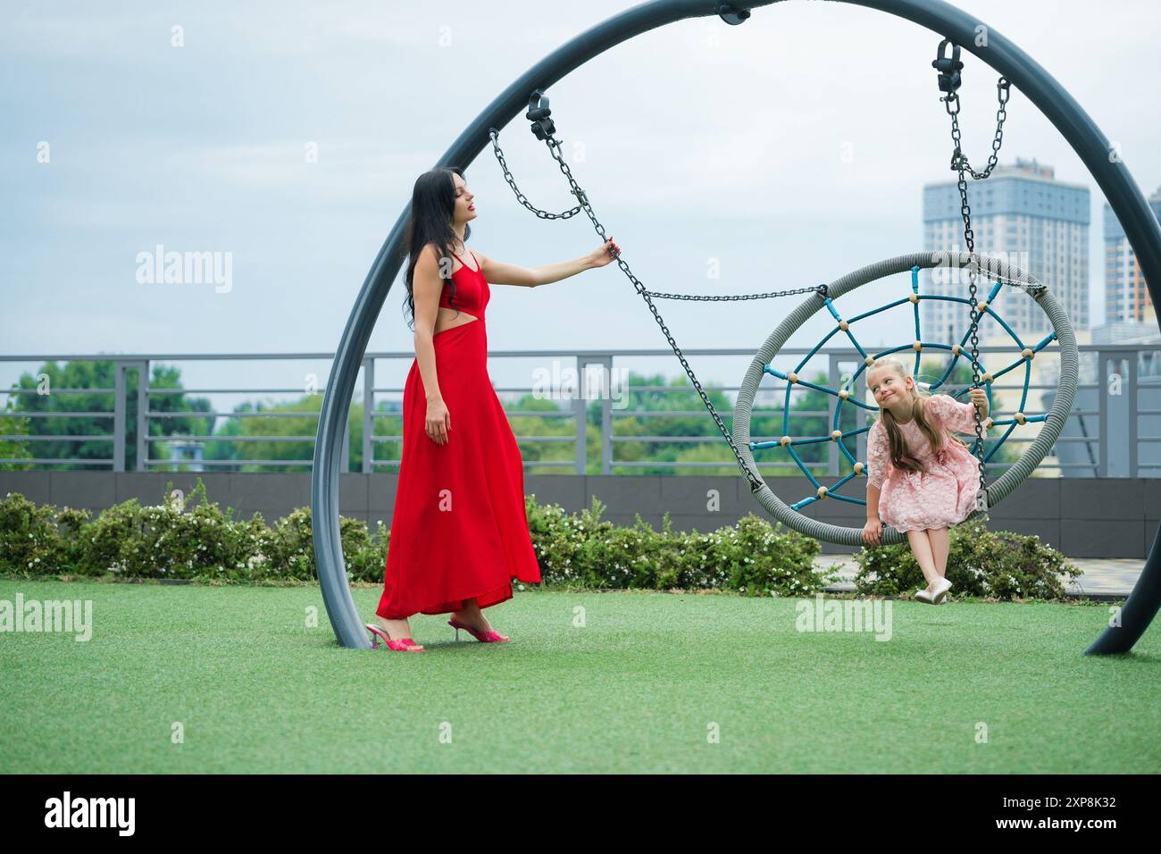 Mother and Daughter Enjoying Playtime Together on Rooftop Playground in ...