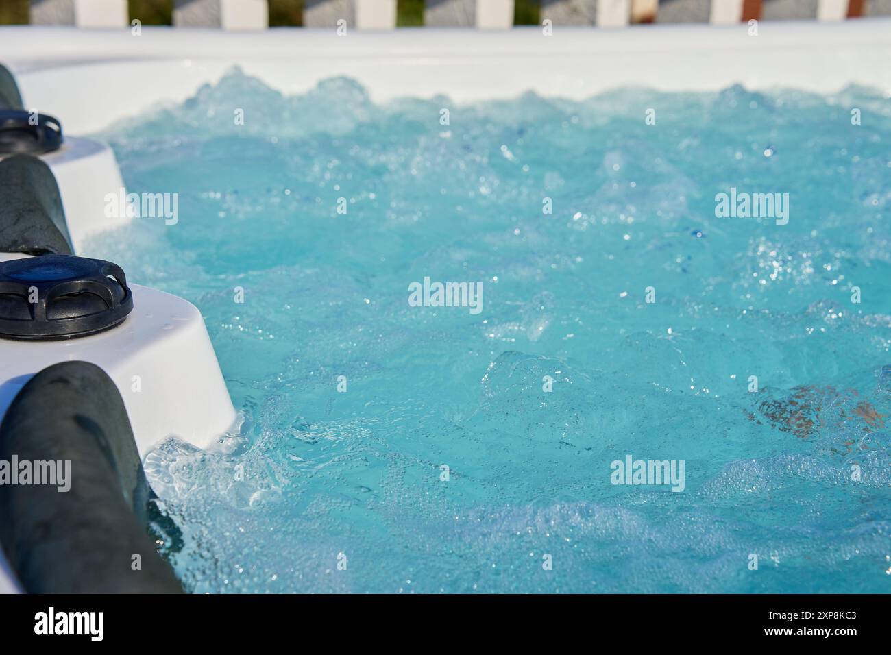 Close-up shot bubbling water in hot tub with headrests. Blue water in ...
