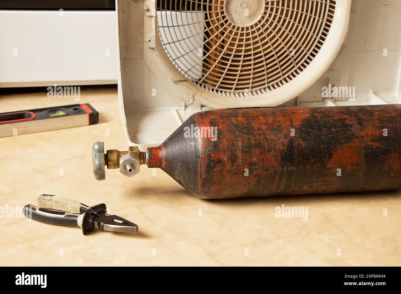 Freon cylinder and disassembled air conditioner on the floor in the ...