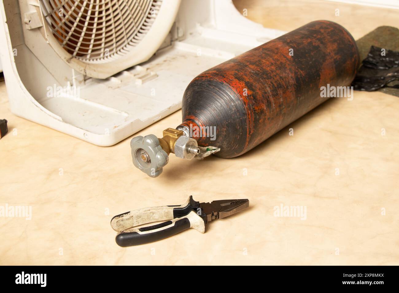 Freon cylinder and disassembled air conditioner on the floor in the ...