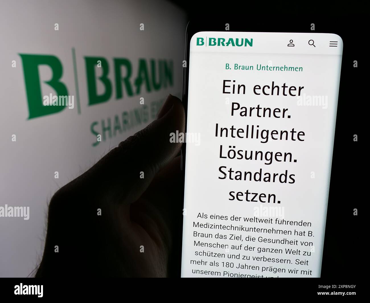 Person holding smartphone with website of Germany pharmaceutical device ...