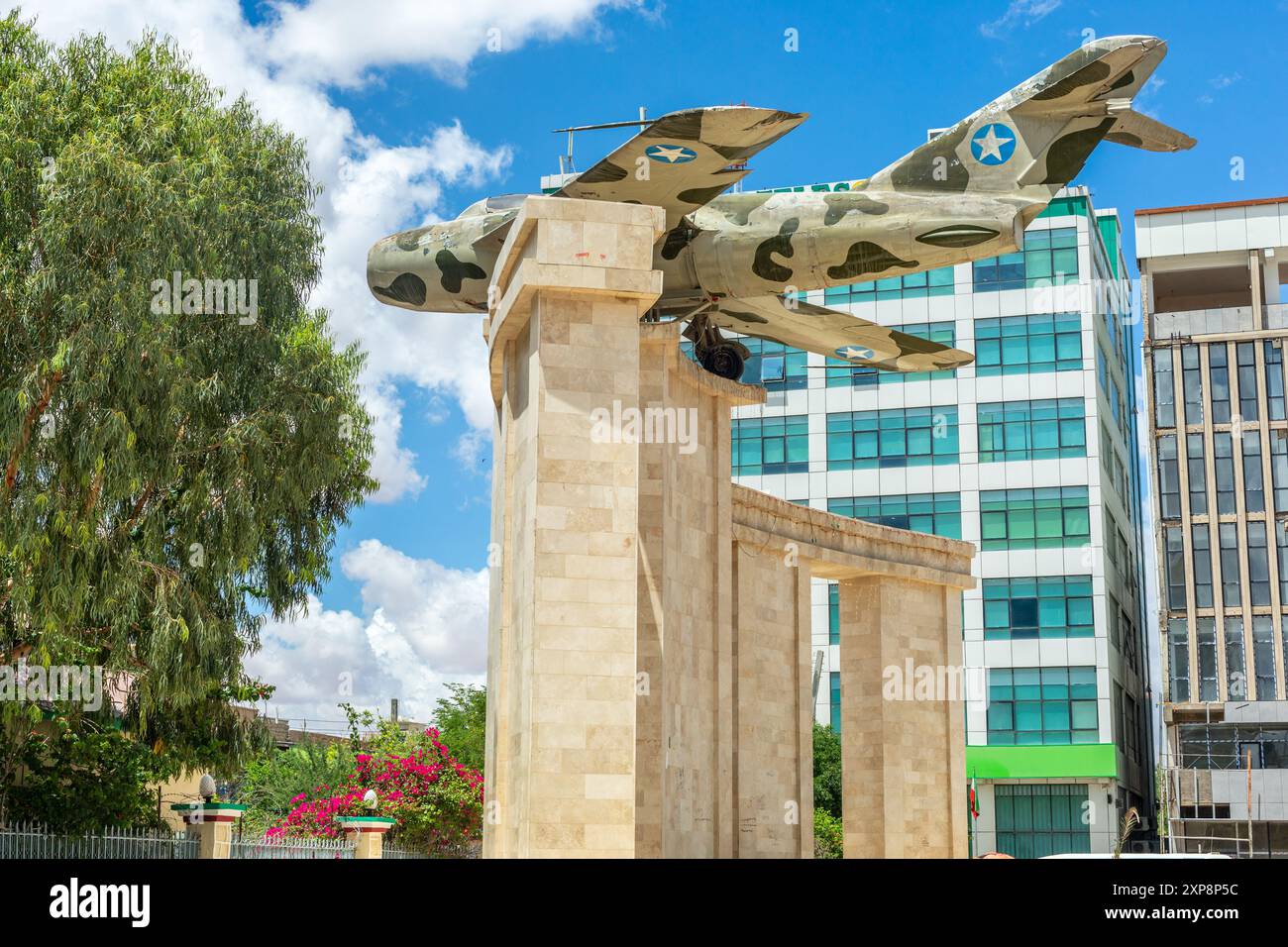 Old war memorial with soviet jet fighter and modern buildings in the ...