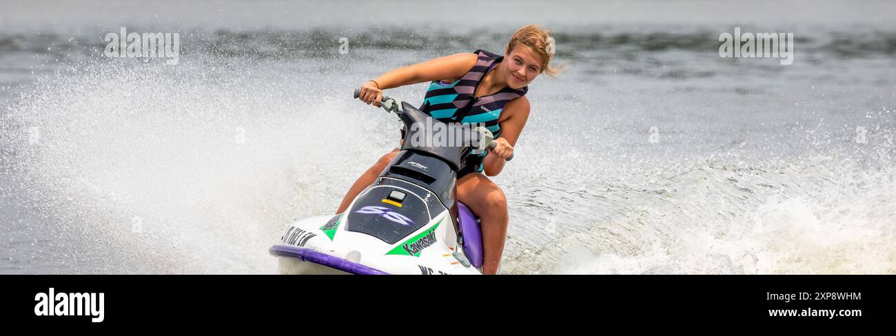 Tomahawk, Wisconsin, USA - July, 30, 2024: Young lady driving a jet ski ...