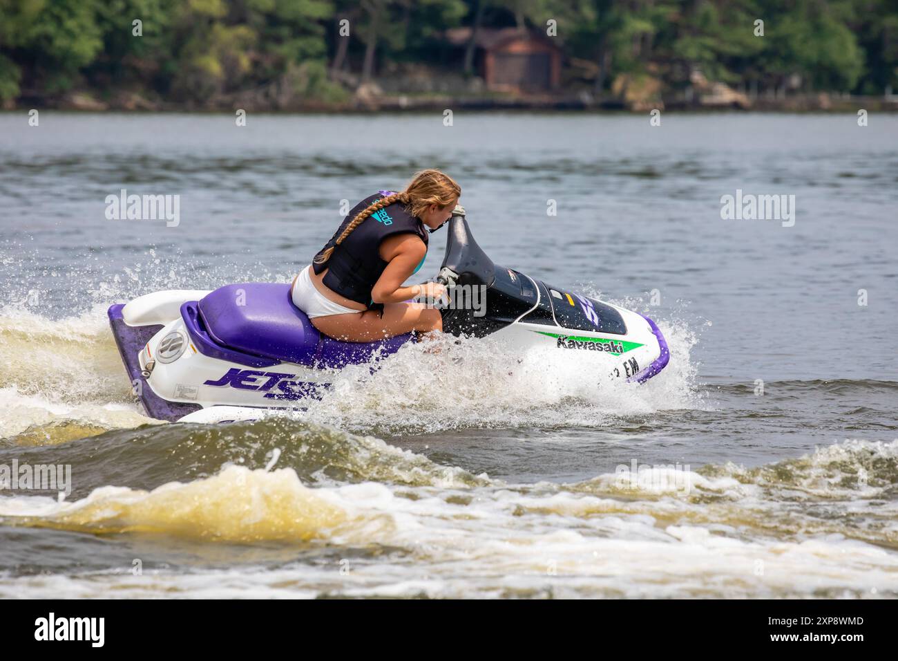 Tomahawk, Wisconsin, USA - July, 30, 2024: Young lady driving a jet ski ...