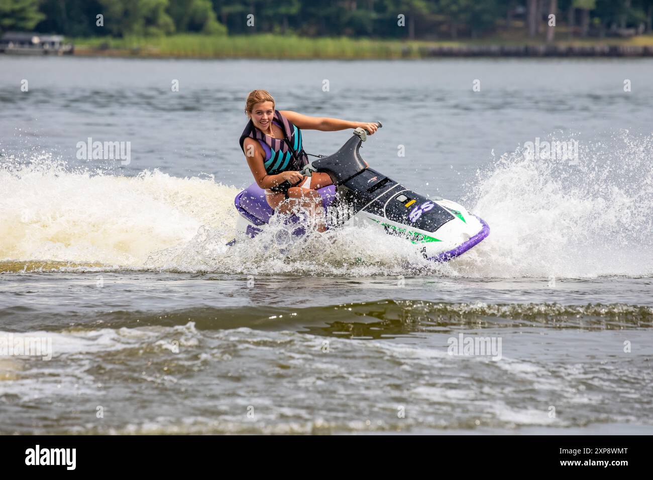 Tomahawk, Wisconsin, USA - July, 30, 2024: Young lady driving a jet ski ...