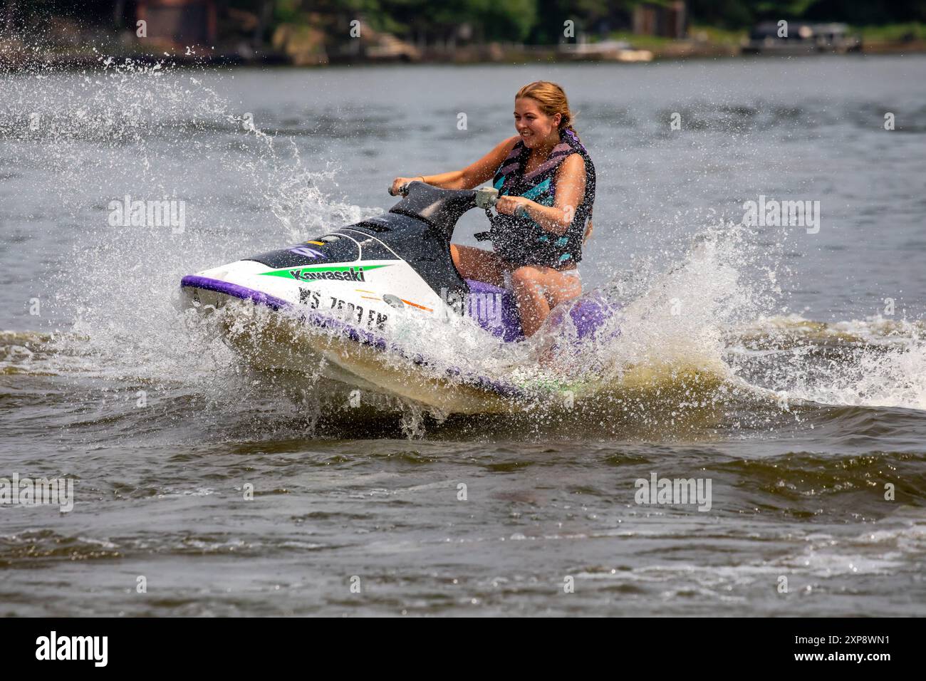 Tomahawk, Wisconsin, USA - July, 30, 2024: Young lady driving a jet ski ...
