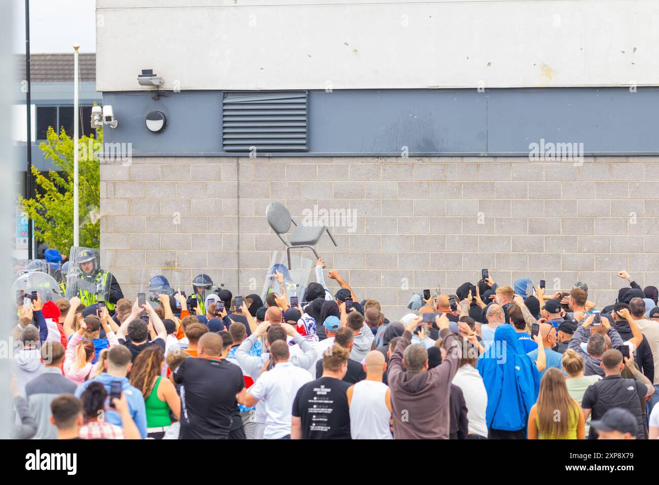 Rotherham, UK. 04 AUG, 2024. Rioters throw a chair as they smash glass ...