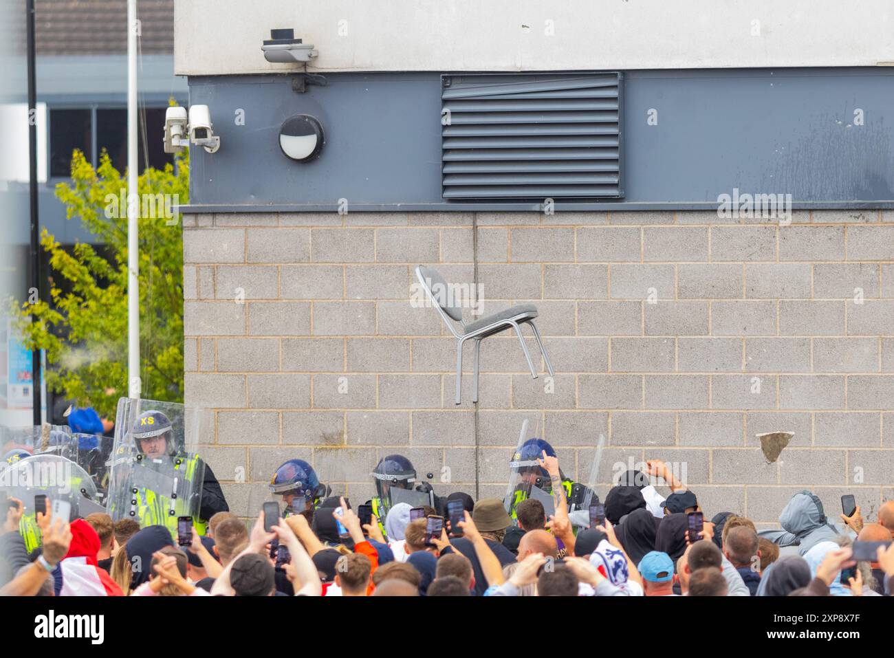 Rotherham, UK. 04 AUG, 2024. Rioters throw a chair as they smash glass ...