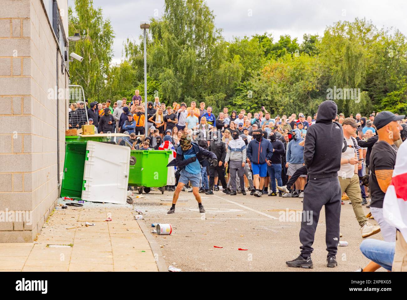 Rotherham, UK. 04 AUG, 2024. Rioters use wood to smash up windows as ...