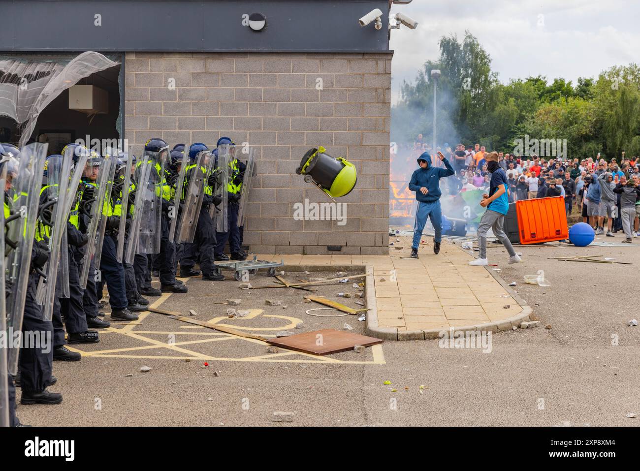 Rotherham, UK. 04 AUG, 2024. A fire is started as a rioter throws ...
