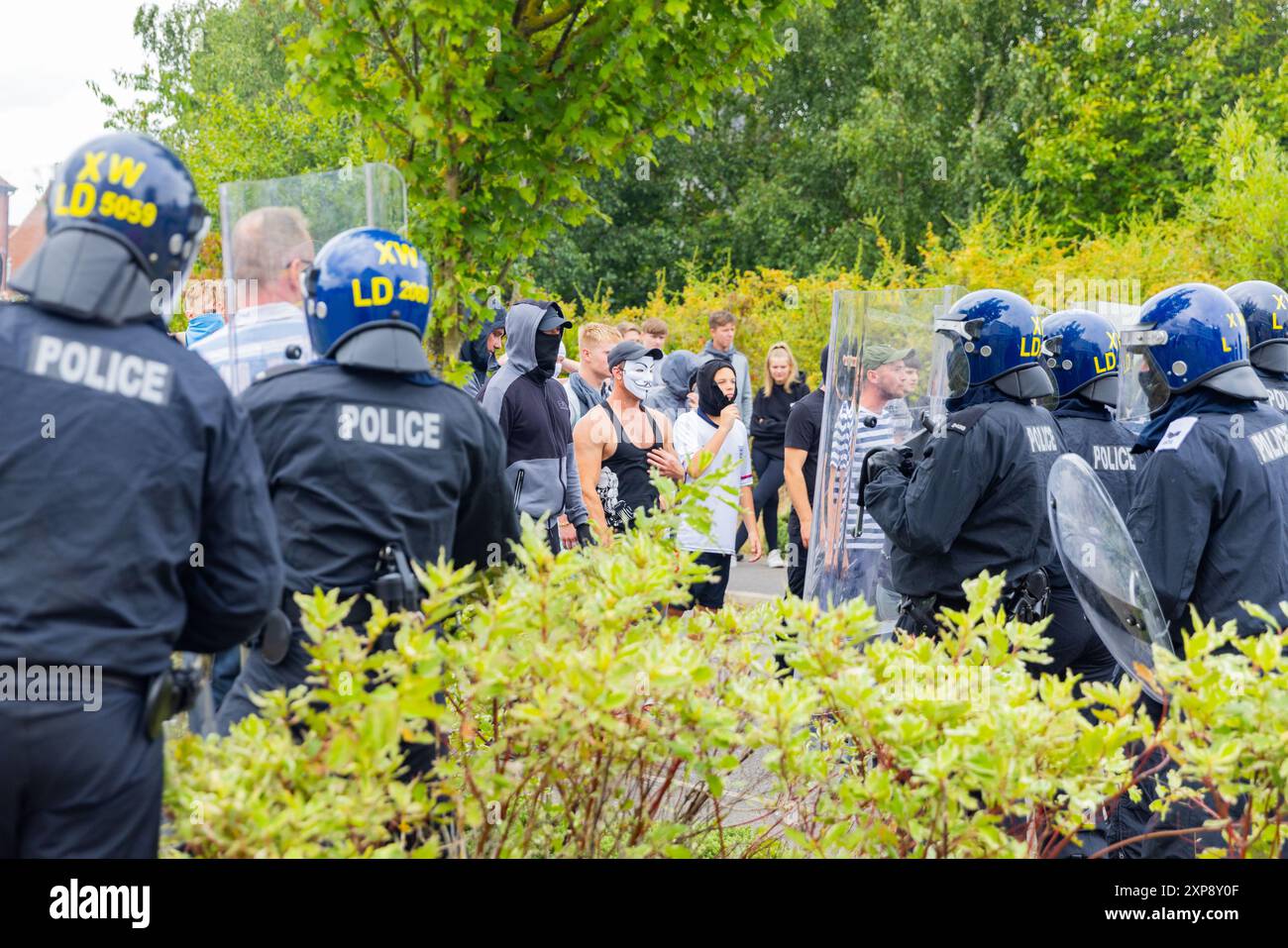 Rotherham, UK. 04 AUG, 2024. Rioters throw small objects and square up ...