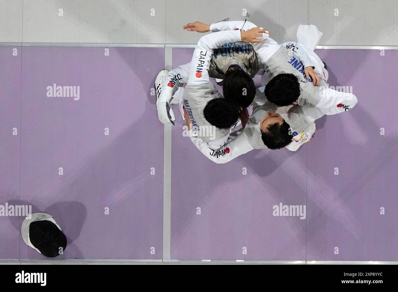 Japan's fencers celebrate after defeating Italy in the men's team foil ...