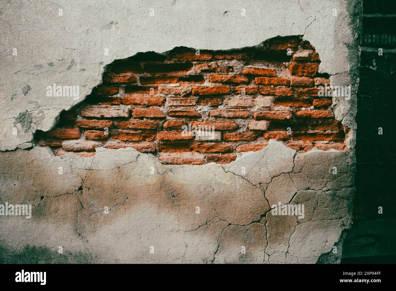 Old building facade with peeling plaster and red brick masonry ...