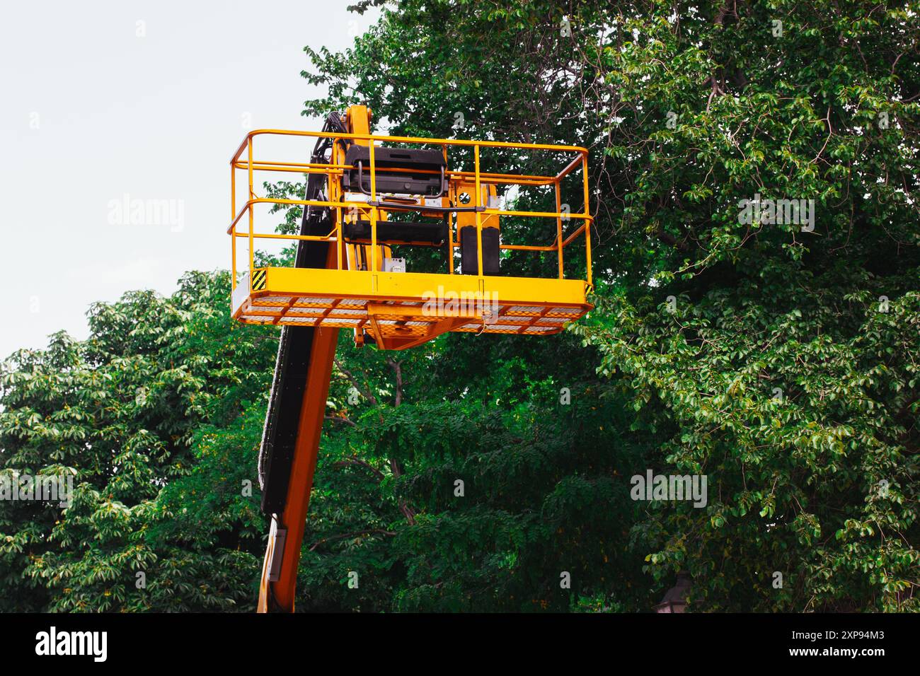 High yellow lift crane with platform for garden works, trees care ...