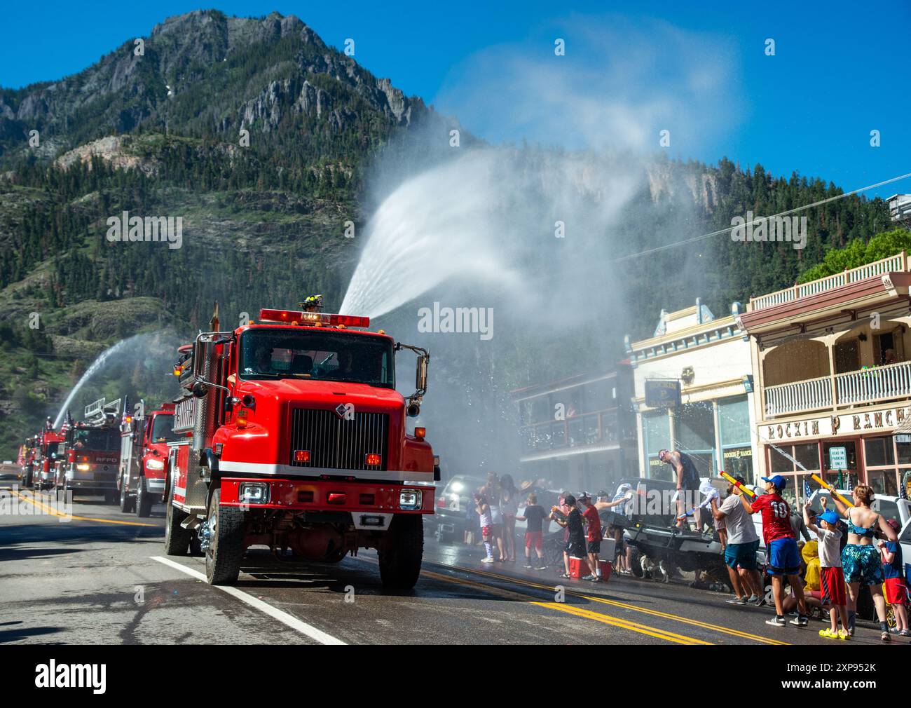 The local fire department uses their water canyon to spray participants ...