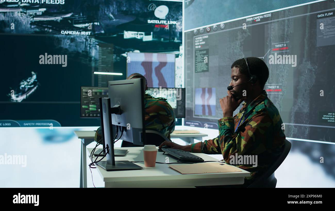 Army professional in uniform works in a mission control center ...