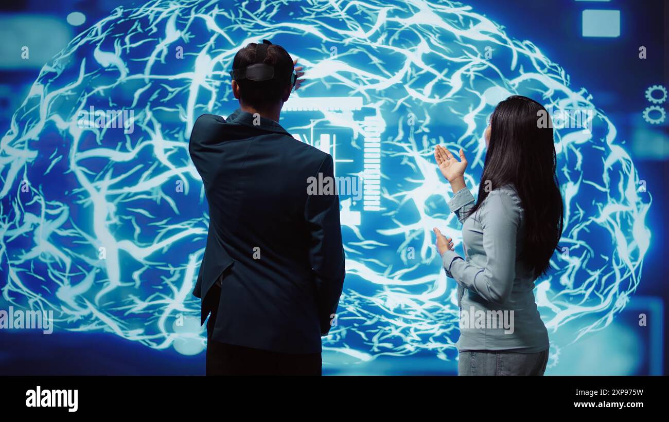 Engineer wearing VR headset and coworker working with artificial intelligence neural networks ...