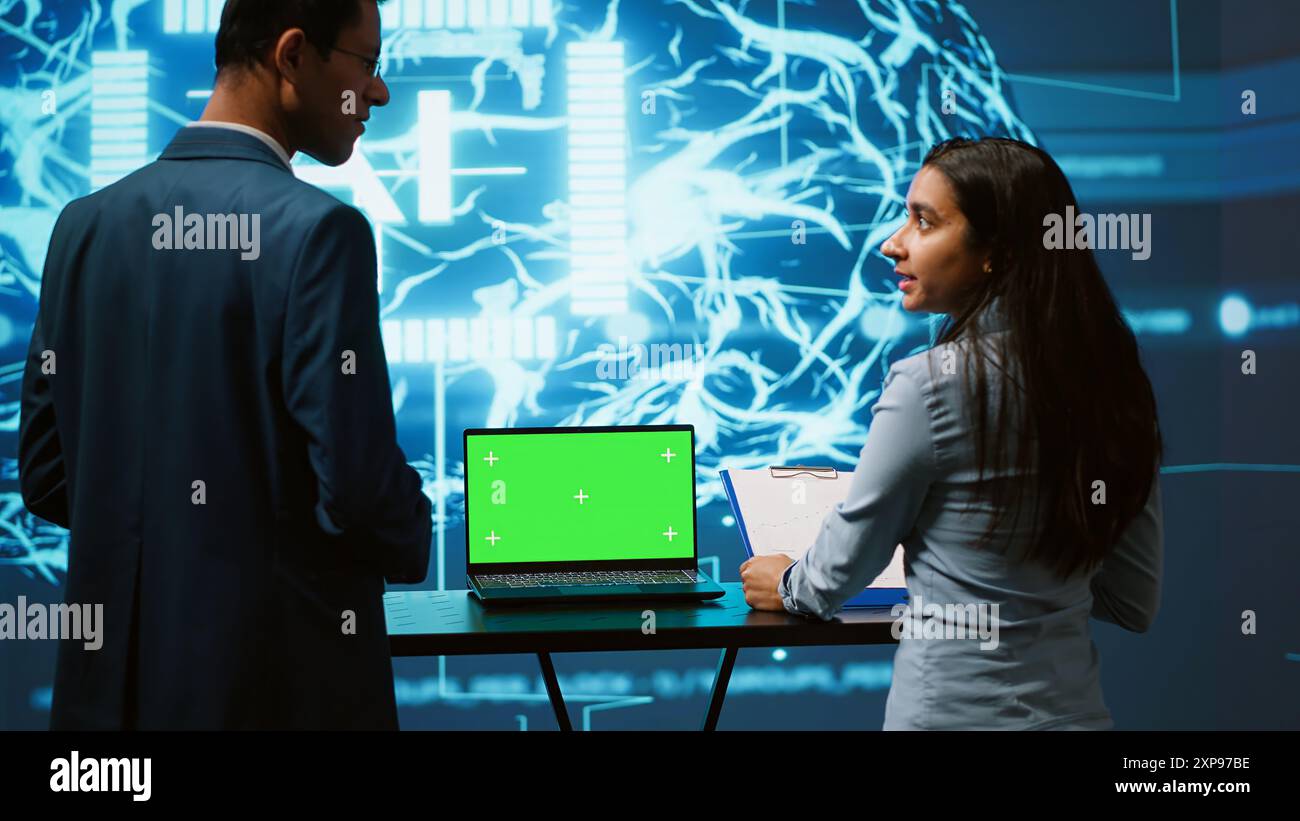 Startup coworkers brainstorming ways to use AI on chroma key notebook to improve data driven ...