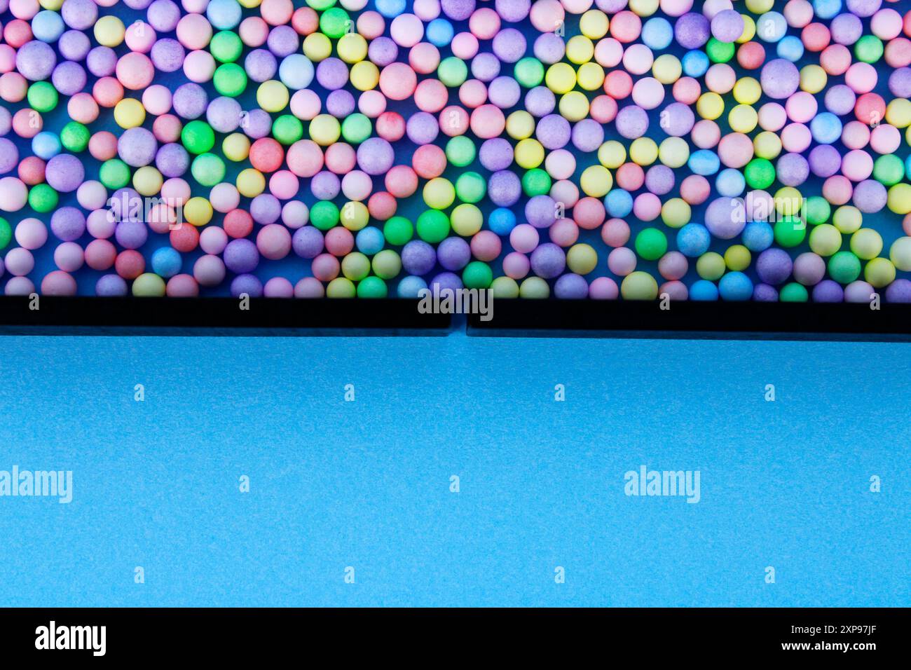 Spheres of different colors grouped behind a wall formed with black ...