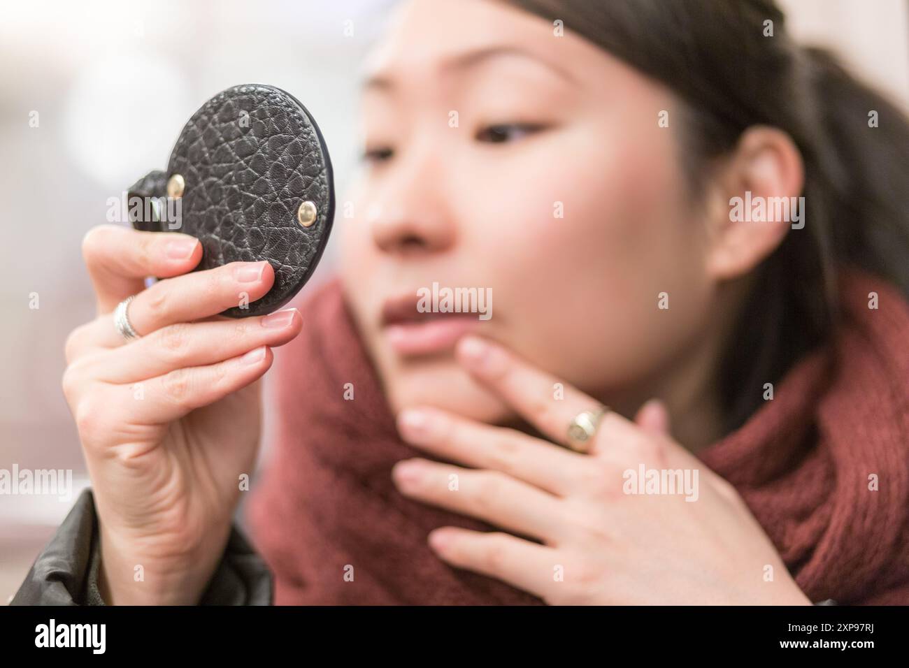 Shallow depth of field portrait of a young Asian woman as she checks ...
