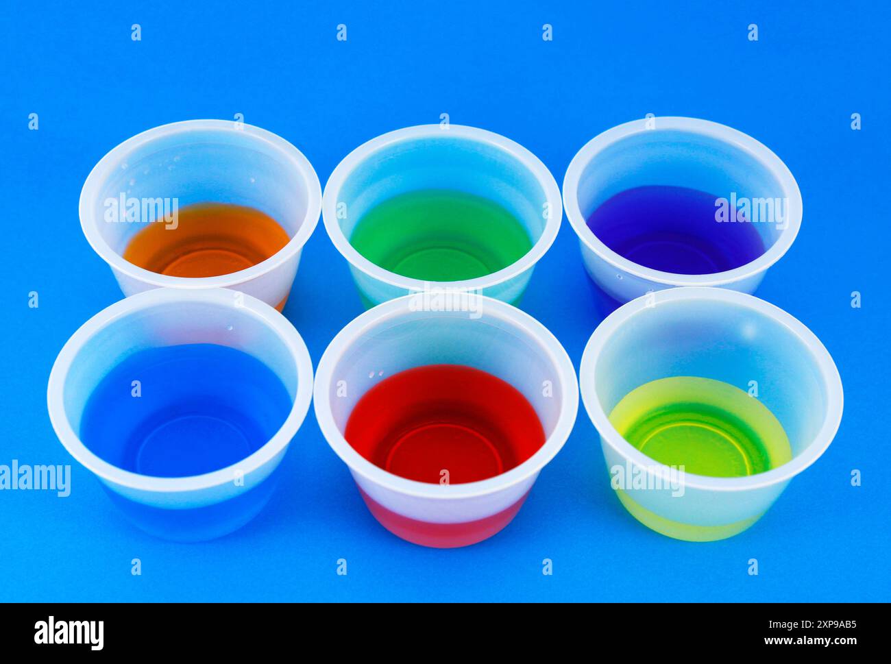 Plastic containers with liquid and rainbow colors Stock Photo - Alamy