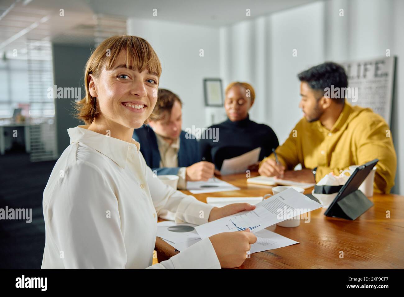 Four young multiracial adults in businesswear meeting at conference ...