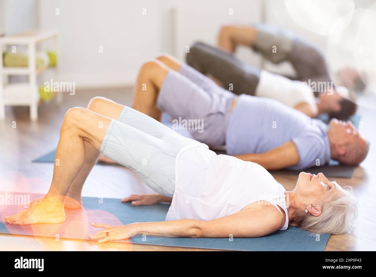 Elderly woman doing pilates in group Stock Photo - Alamy