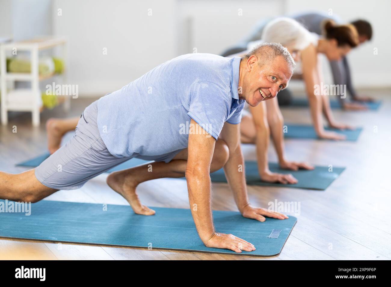 Elderly man doing pilates in group Stock Photo - Alamy