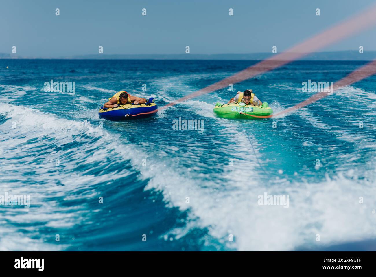 Two people enjoying speedboat tubing on a summer day in the sea Stock ...