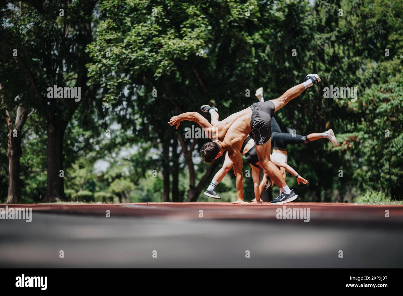 Group of athletes performing acrobatics in park during workout session ...