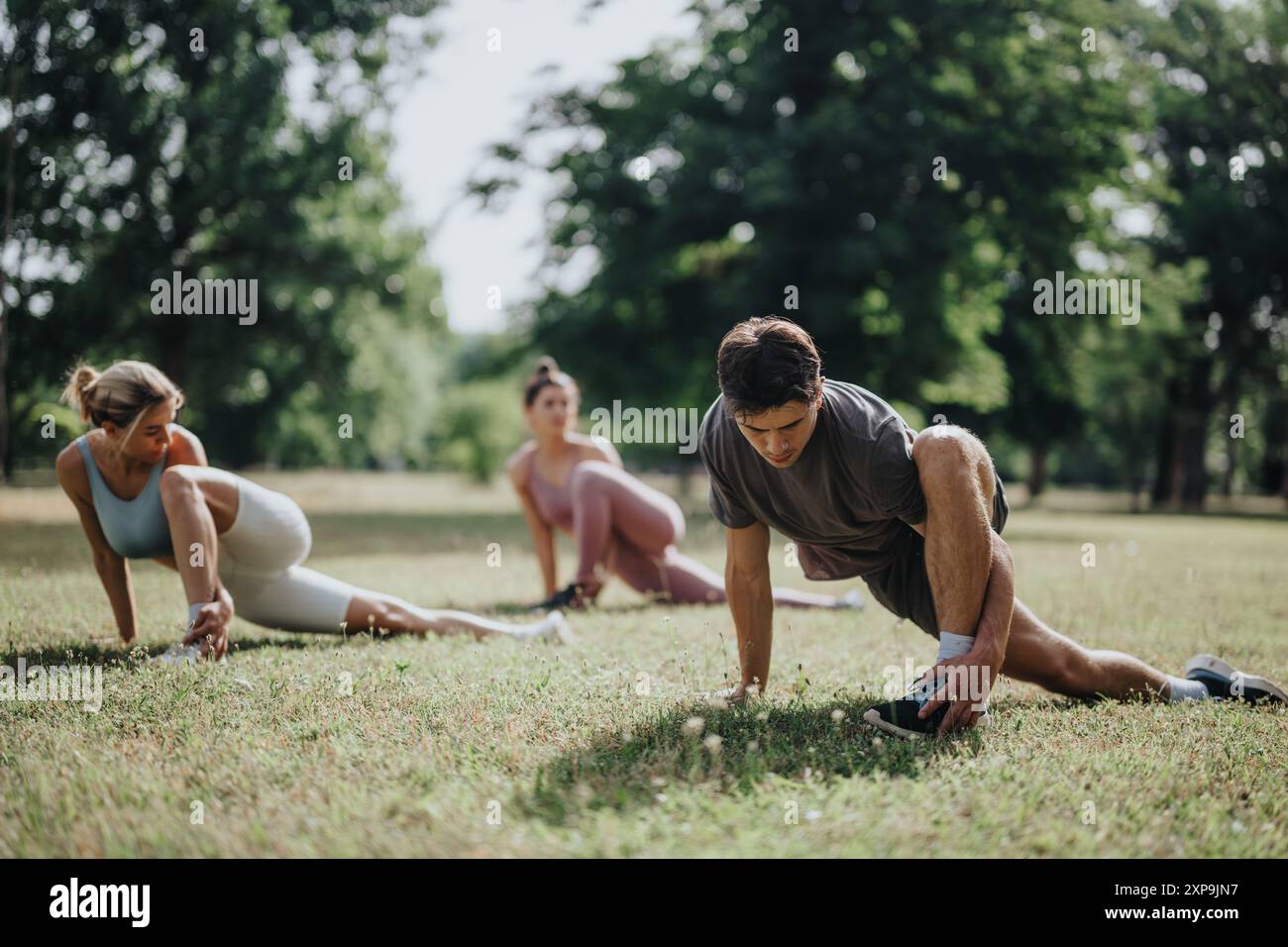 Group of young people doing calisthenics exercises in the park for a ...