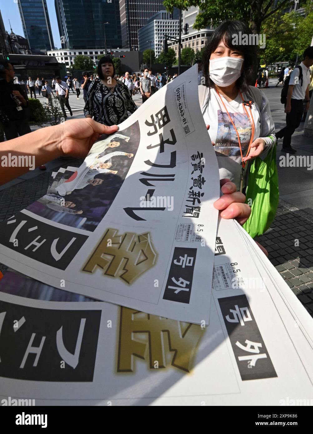 An extra newspaper is distributed in Tokyo on August 5, 2024, reporting ...