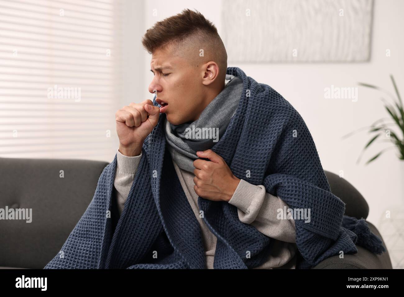 Cold symptom. Young man coughing at home Stock Photo - Alamy