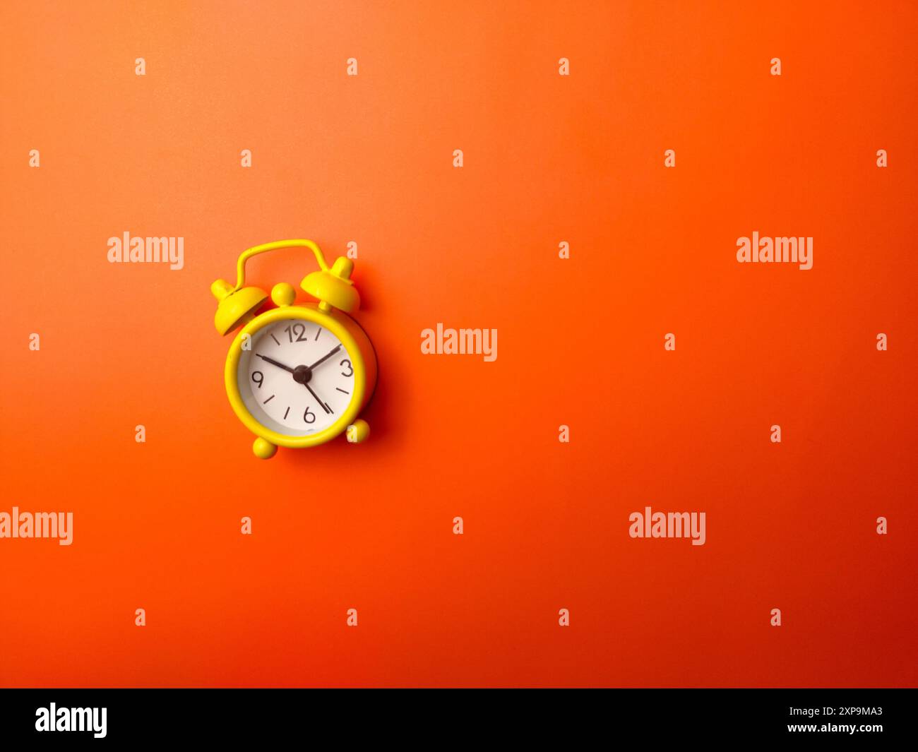 Top view yellow clock on a orange background with copy and text space ...