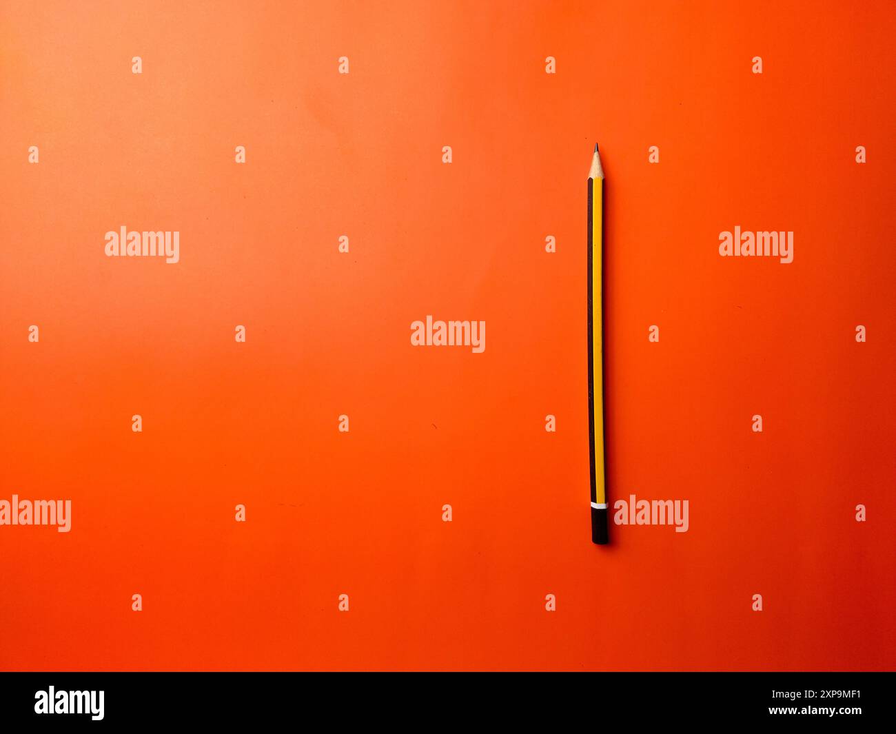Top view yellow pencil on a orange background with copy and text space ...