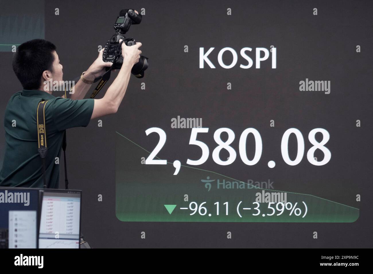 A photographer takes a photo of a screen showing the Korea Composite ...
