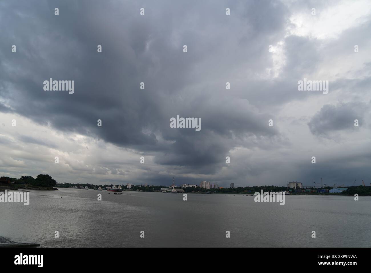 Heavy monsoon clouds hover over the Ganges, with the Kolkata skyline in ...
